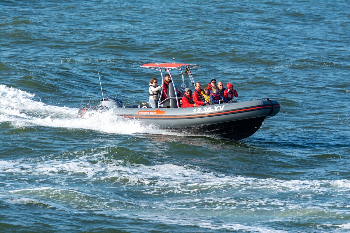 Group of travelers in an inflatable boat on a sunny day at sea