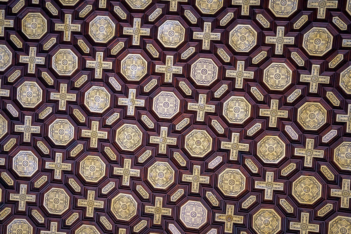 Looking up at an ornate geometric ceiling pattern inside a Seville palace
