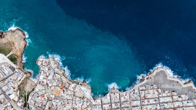 Aerial view of Polignano a Mare showing the clifftop town and turquoise Adriatic Sea