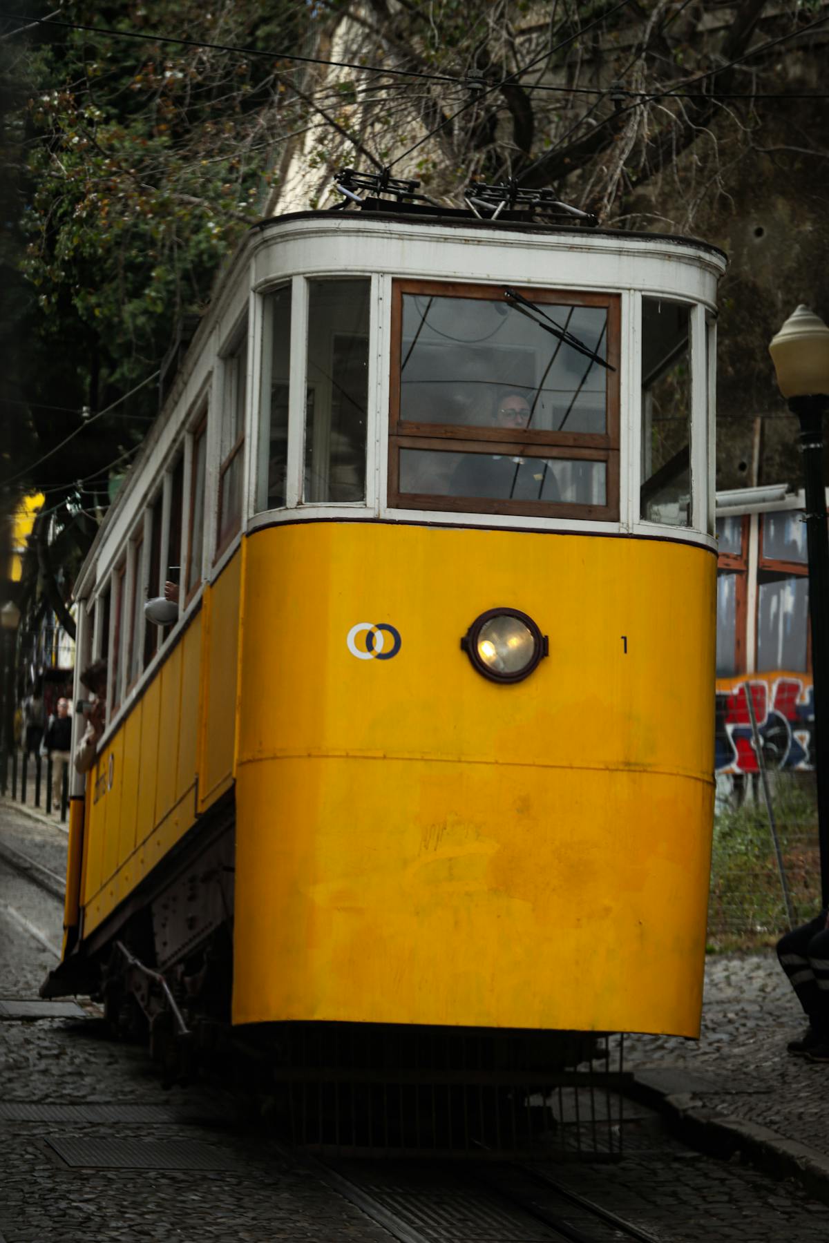 Yellow tram on cobblestone street in Lisbon