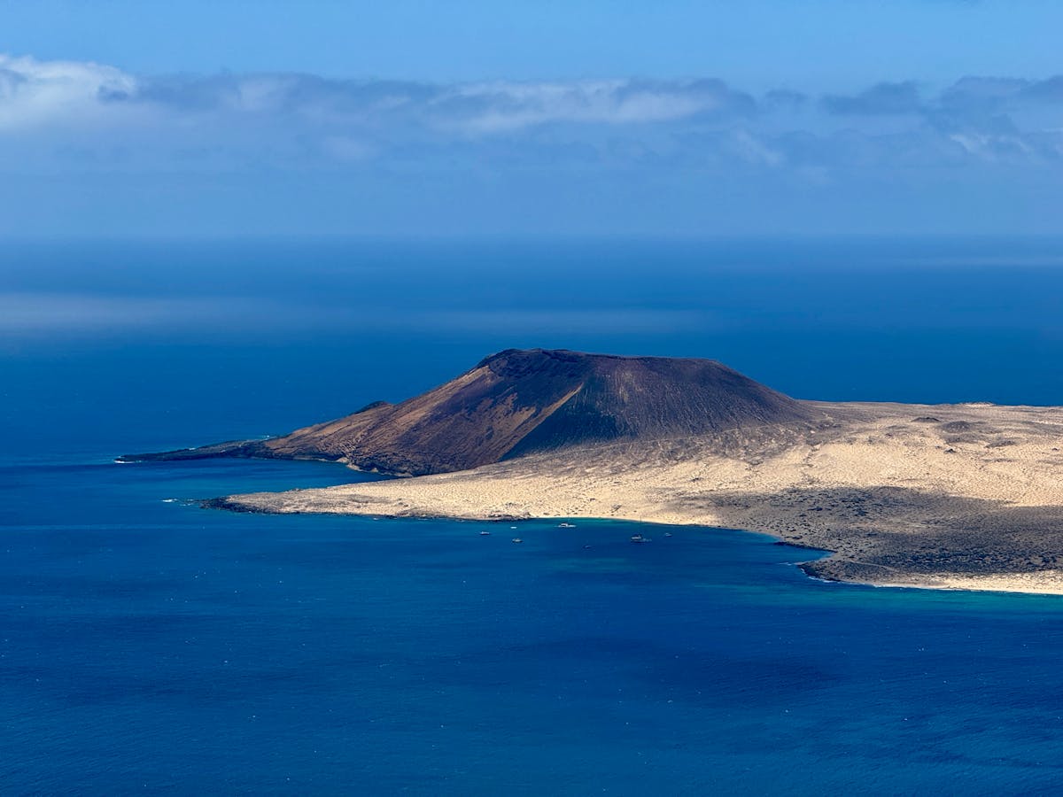 Stunning aerial view of Lanzarote rugged volcanic coastline meeting the blue Atlantic Ocean