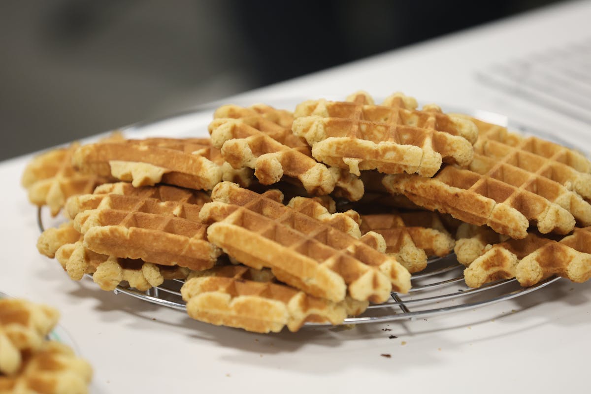 Freshly baked golden waffles stacked on a wire cooling rack