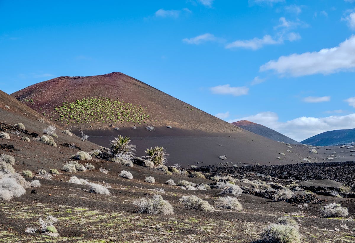 Barren volcanic terrain of Timanfaya National Park in Lanzarote Spain under blue skies