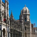 The ornate Manueline facade of Jeronimos Monastery in Lisbon under a clear blue sky