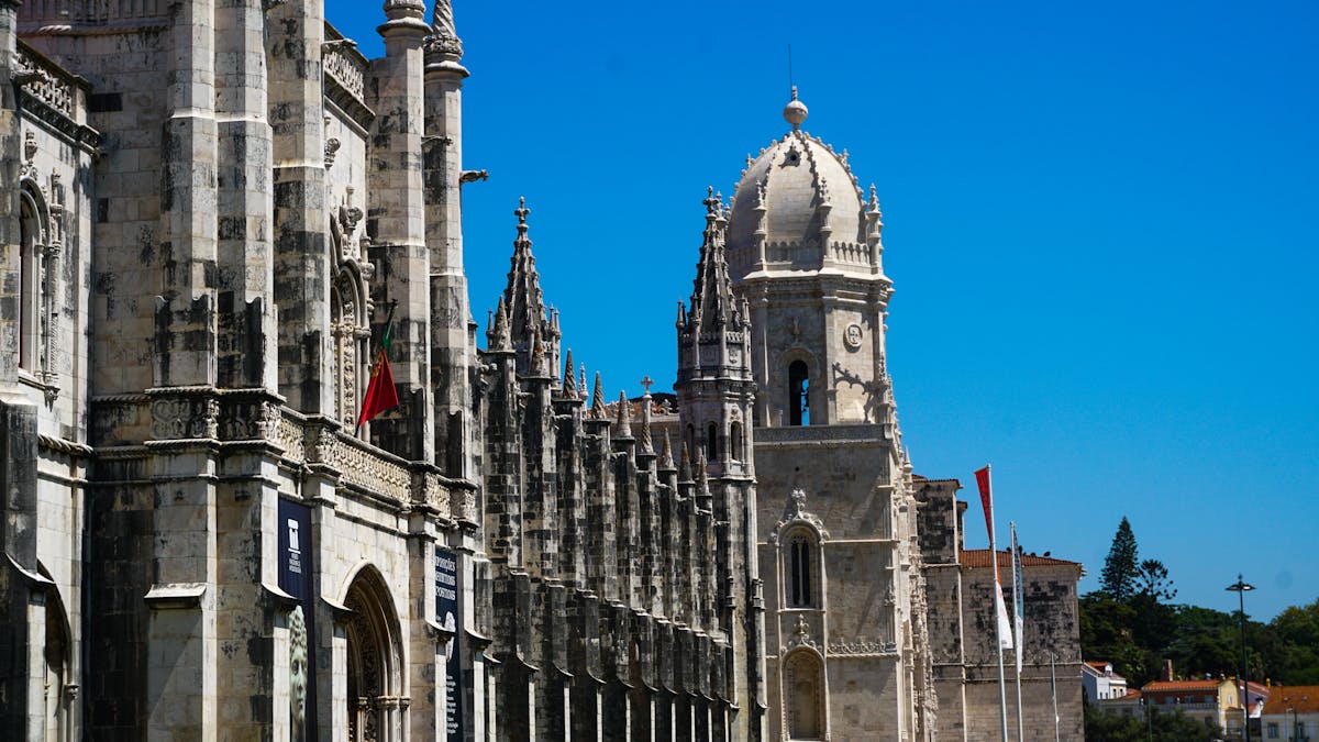 The ornate Manueline facade of Jeronimos Monastery in Lisbon under a clear blue sky
