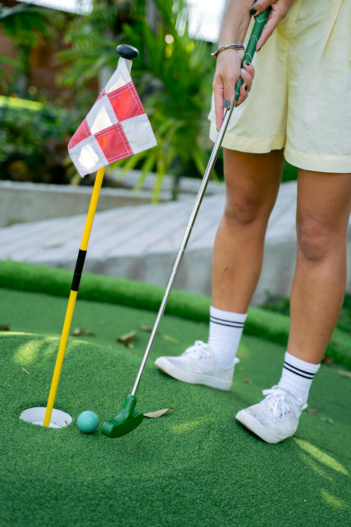 Close-up of a woman putting a golf ball at a mini golf course