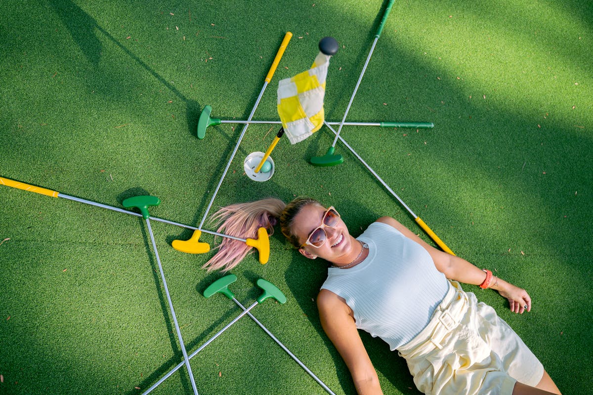Woman enjoying a sunny day at a mini golf course