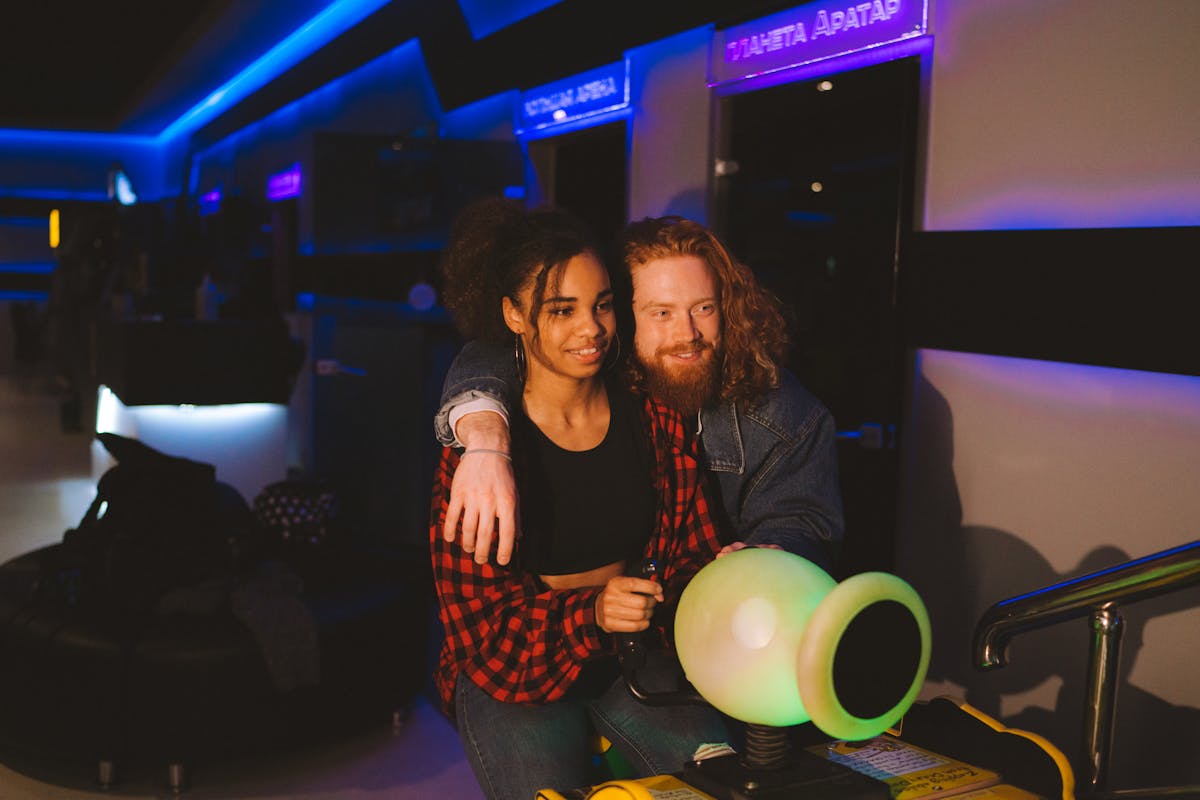 Happy couple having fun at an illuminated indoor arcade