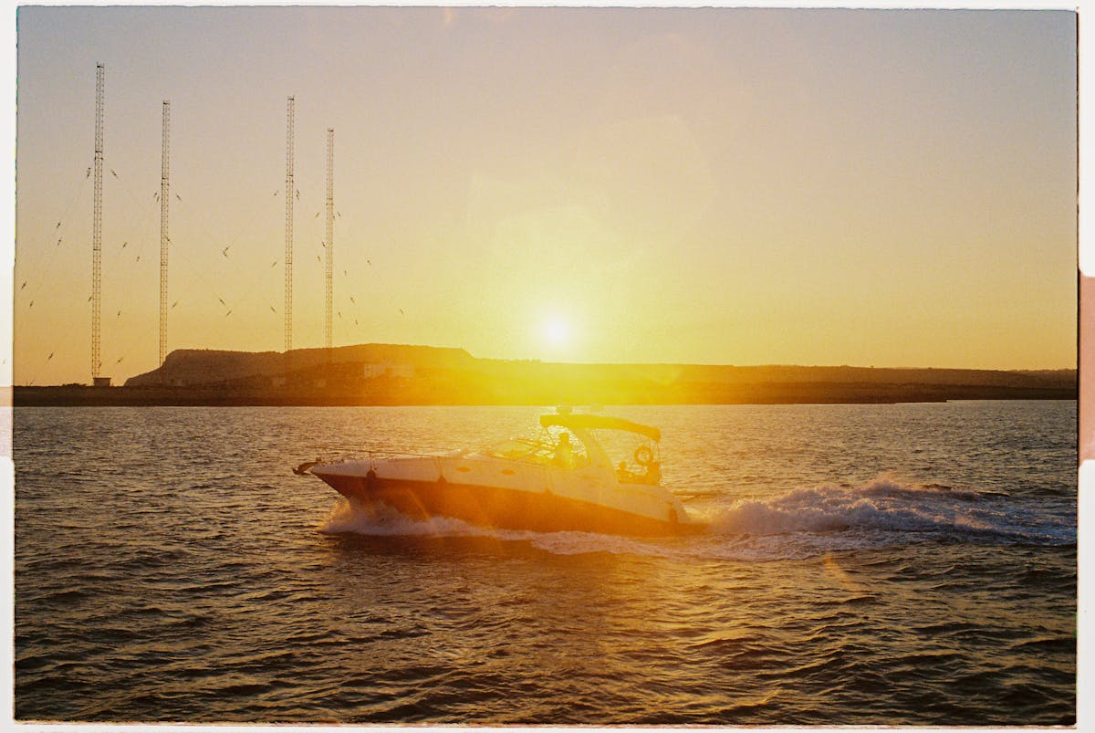A speedboat glides through the ocean at sunset on the Mediterranean Sea