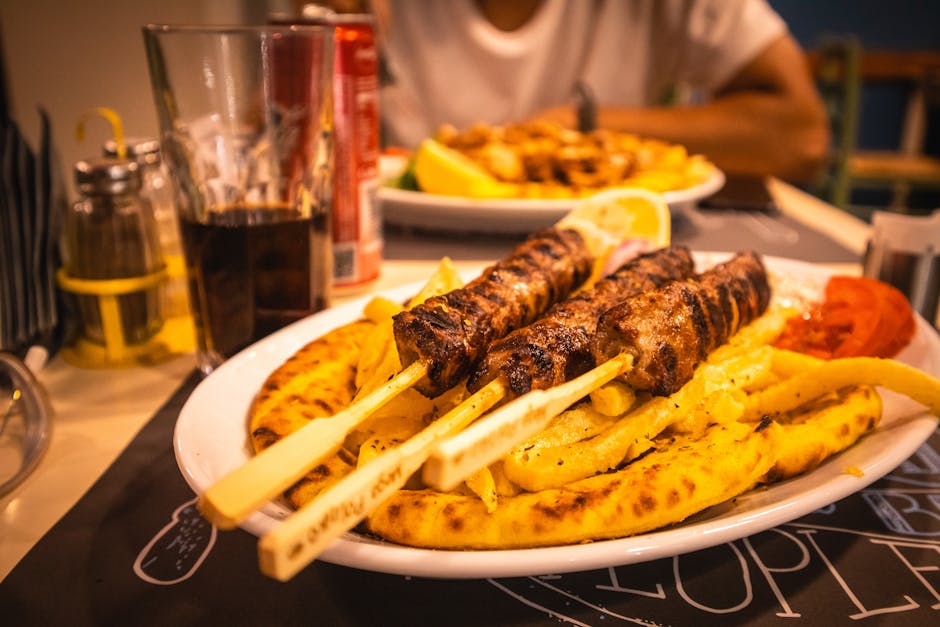 Grilled meat skewers served with fries and pita bread