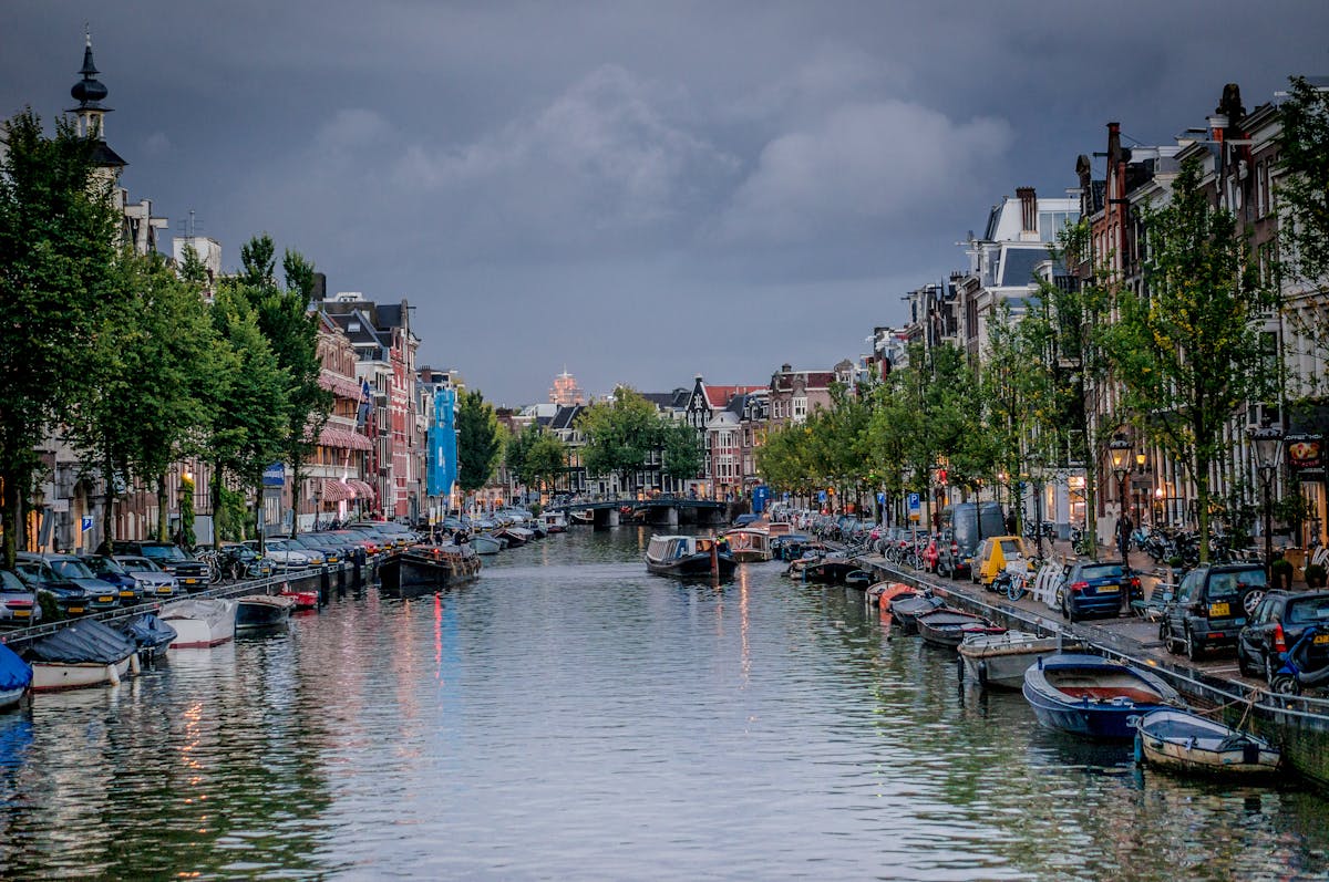 A picturesque view of an Amsterdam canal with boats and traditional buildings