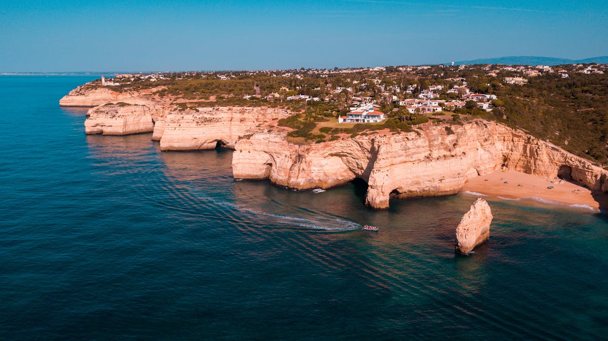 Aerial view of Algarve rugged cliffs and turquoise seas