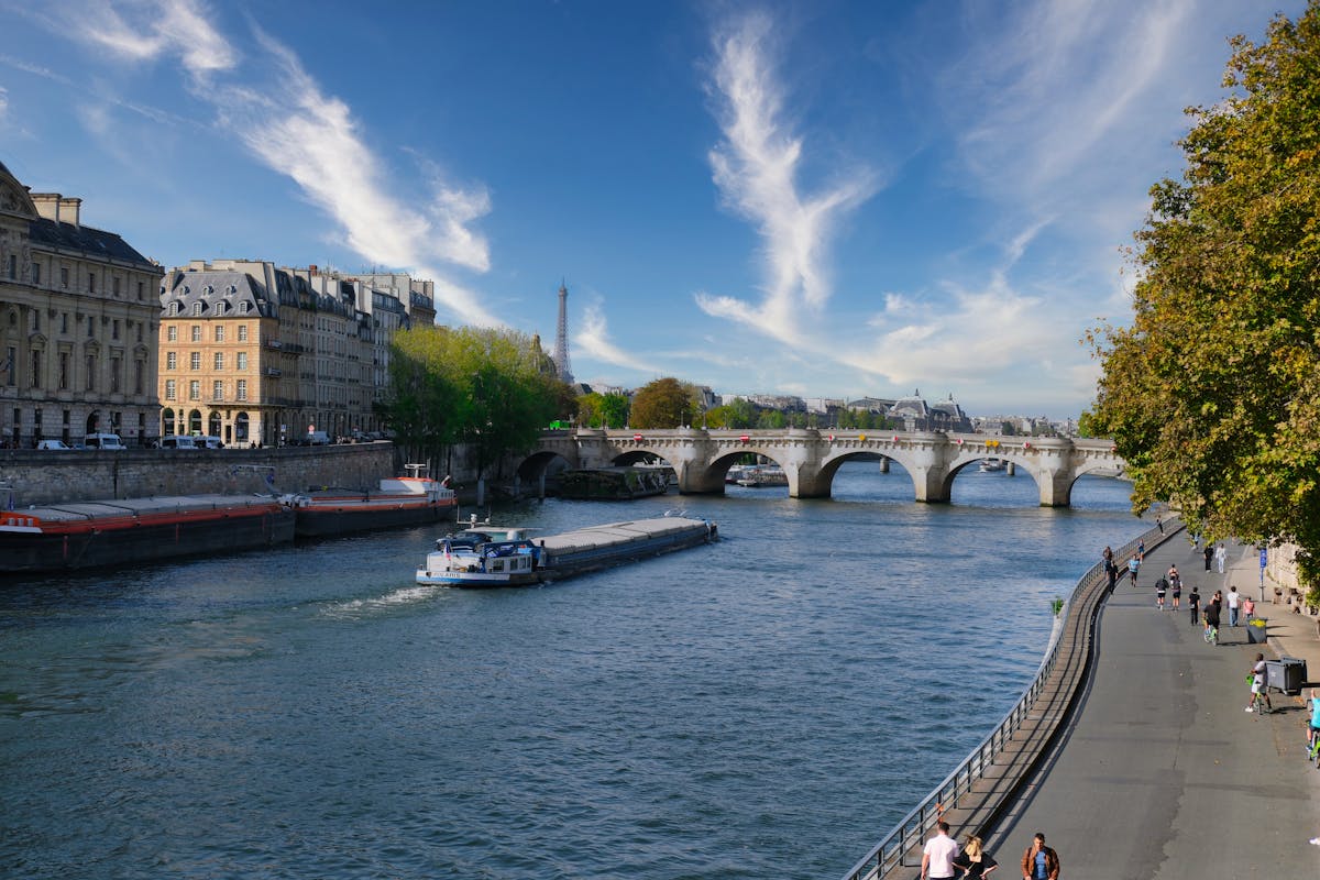Eiffel Tower and Seine River with historical Parisian architecture under blue skies