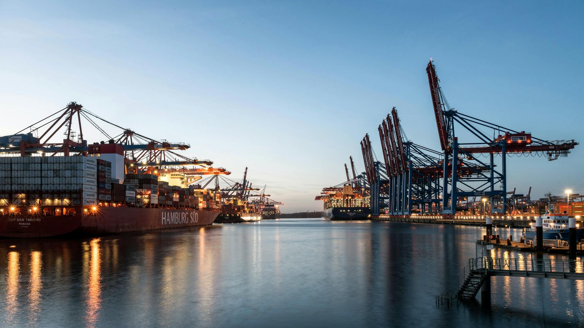 Cargo ships and cranes at the Port of Hamburg during sunset