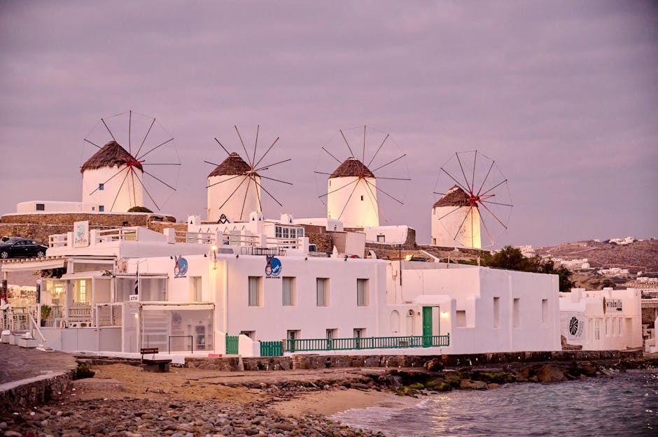The iconic Mykonos windmills at twilight with whitewashed buildings