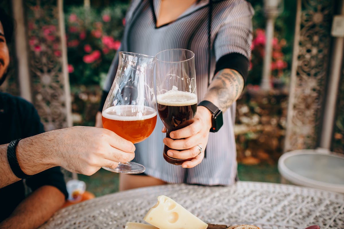 A group of friends enjoying craft beers and cheese outdoors together