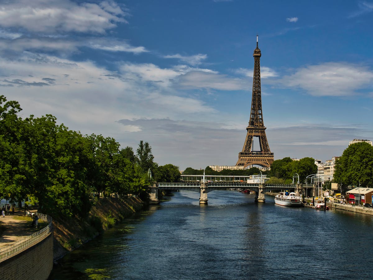 Eiffel Tower and Seine River in Paris captured on a sunny day with boats below