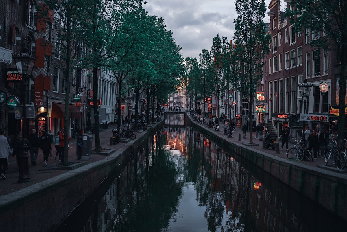 A busy evening scene along an Amsterdam canal at twilight