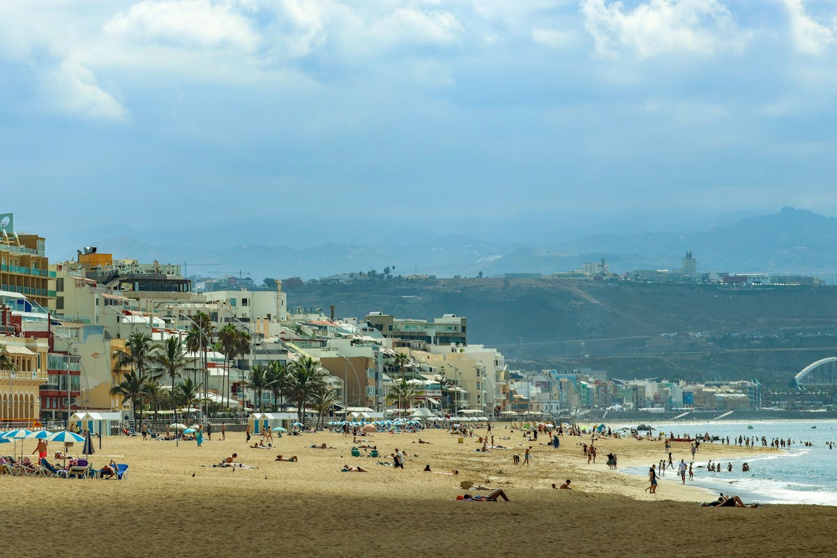 Sandy beach with sunbathers along the coast of Las Palmas in Gran Canaria