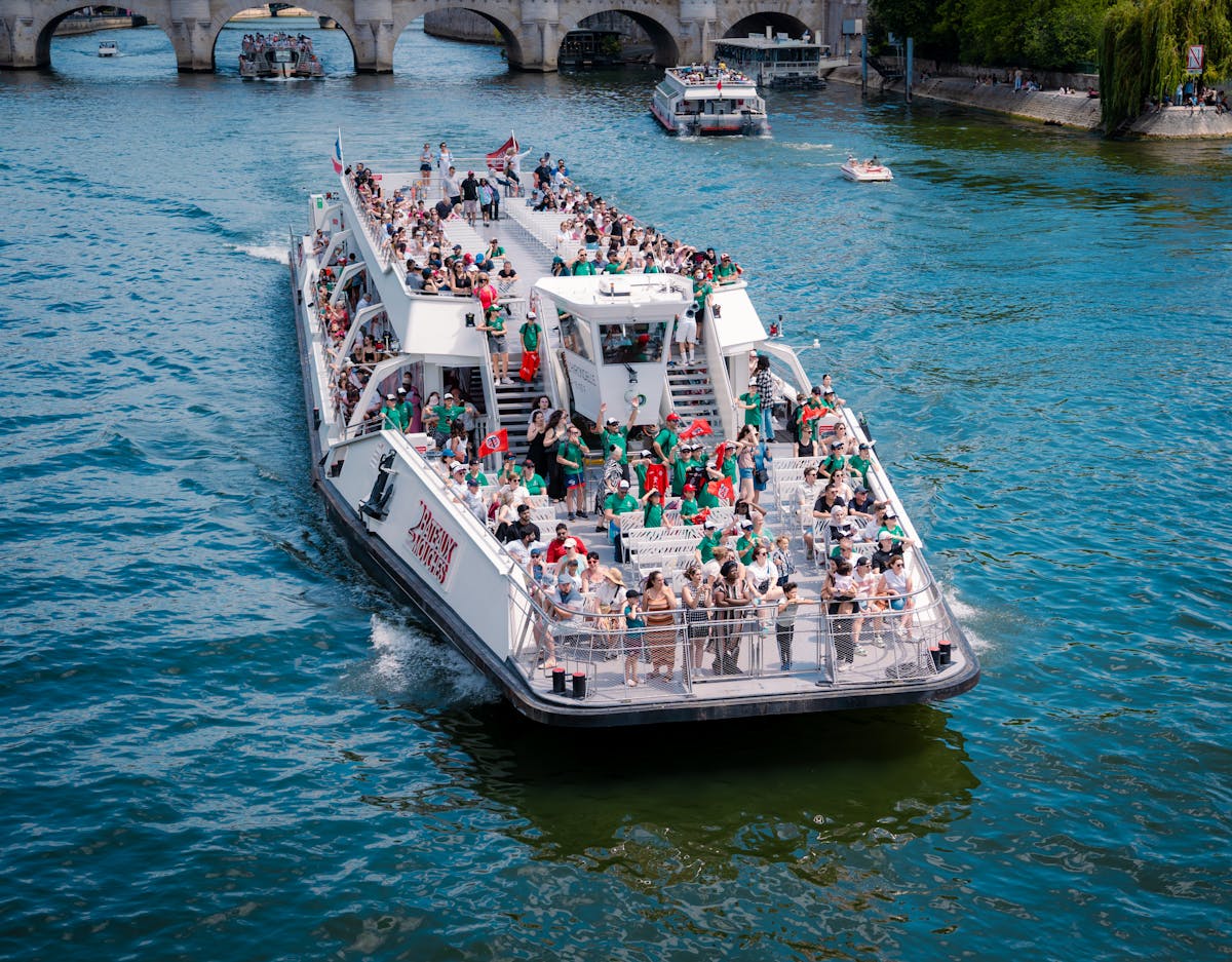 Crowded sightseeing boat cruising the Seine River past Paris landmarks