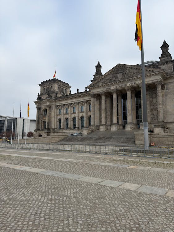 Historic Reichstag building facade with German flags waving