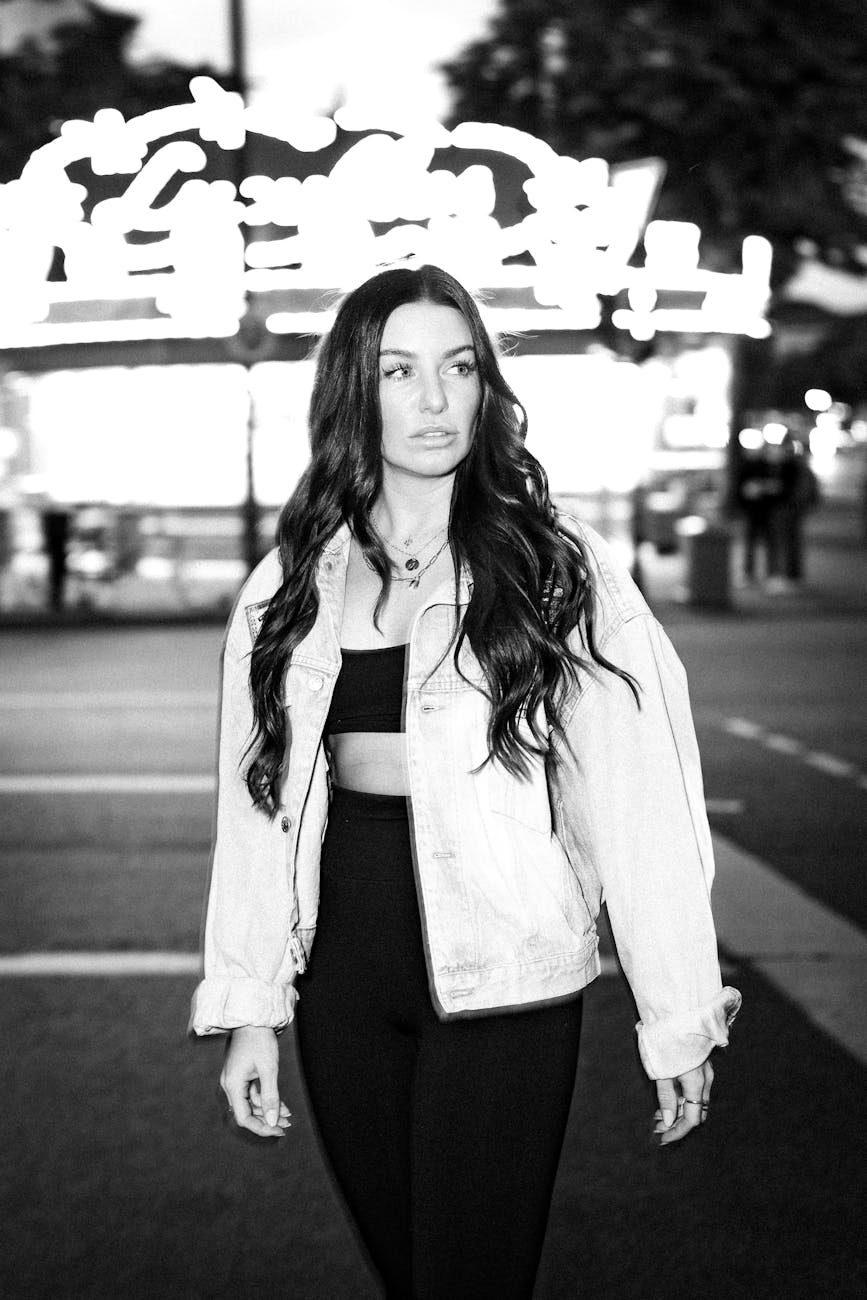 Black and white portrait of a woman walking on the Reeperbahn at night
