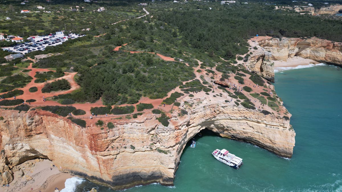 Aerial shot of Algarve cliffs and coastline with boats