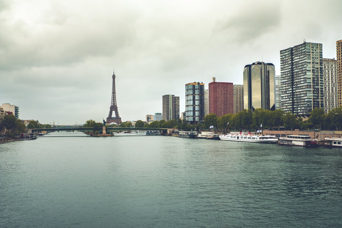 Eiffel Tower and Paris skyline with the Seine River under dramatic cloudy skies