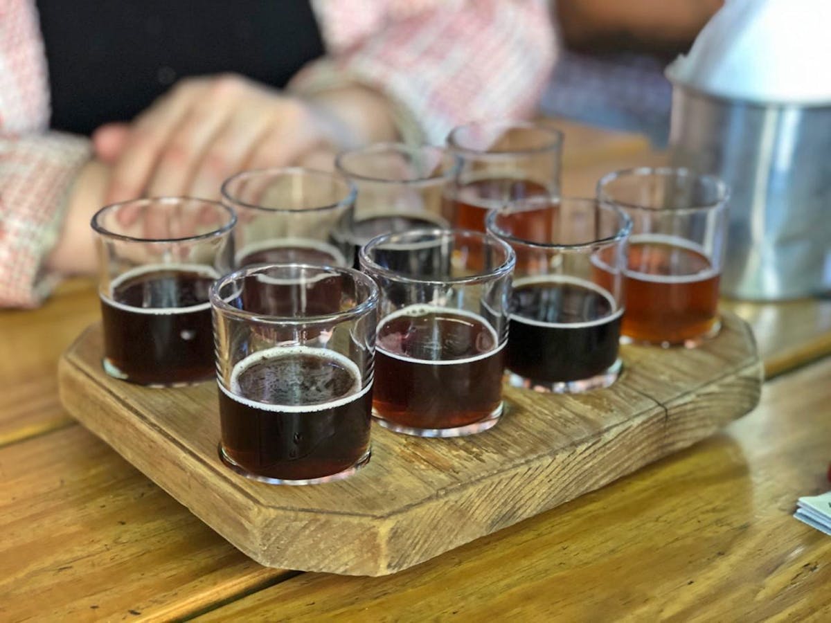 A variety of craft beers served on a wooden tasting tray