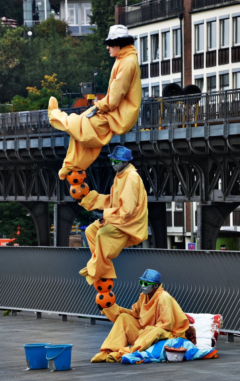 Street performers showing balance skills in Hamburg with colorful costumes