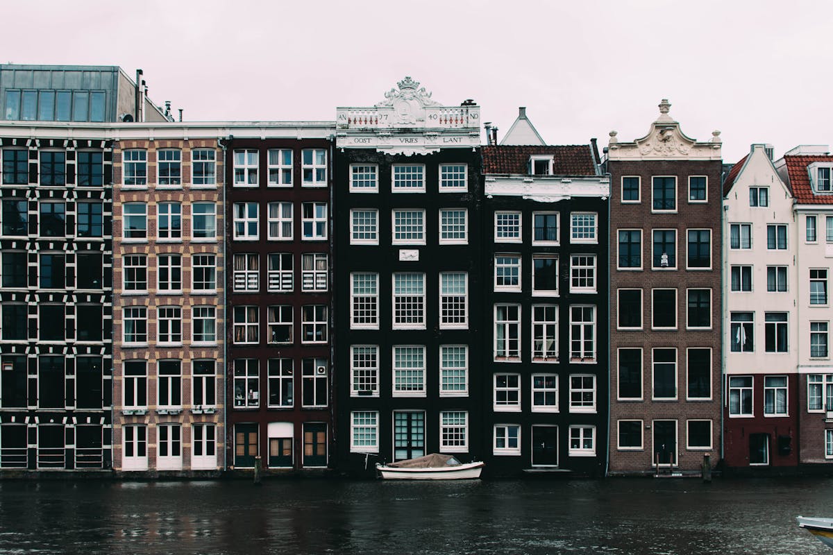 Charming Amsterdam canal houses mirrored in the still water of a canal