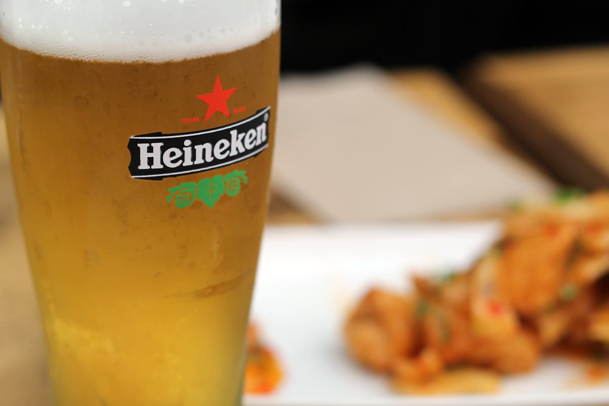 A chilled Heineken beer with snacks served outdoors on a sunny day