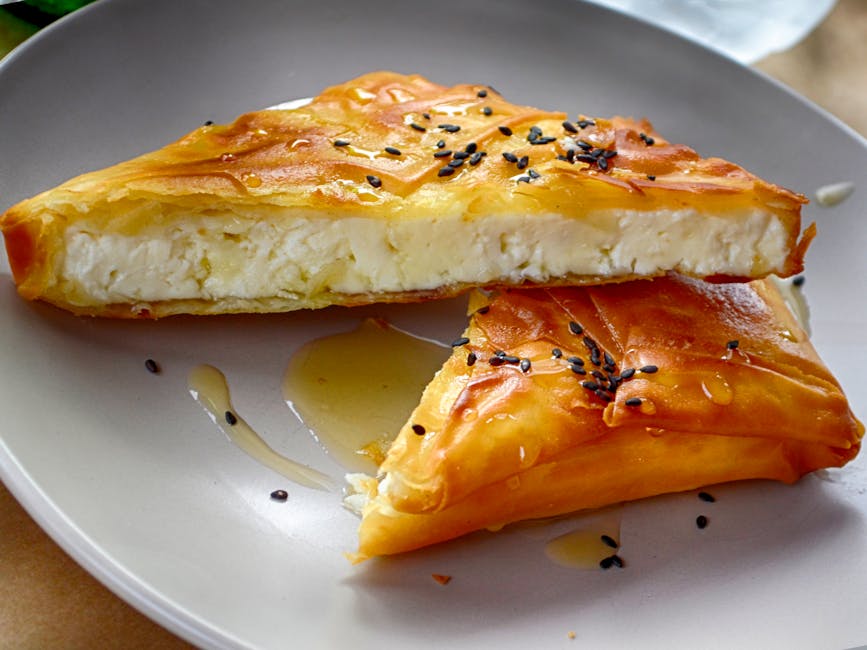 Greek cheese pie drizzled with honey and garnished with sesame seeds