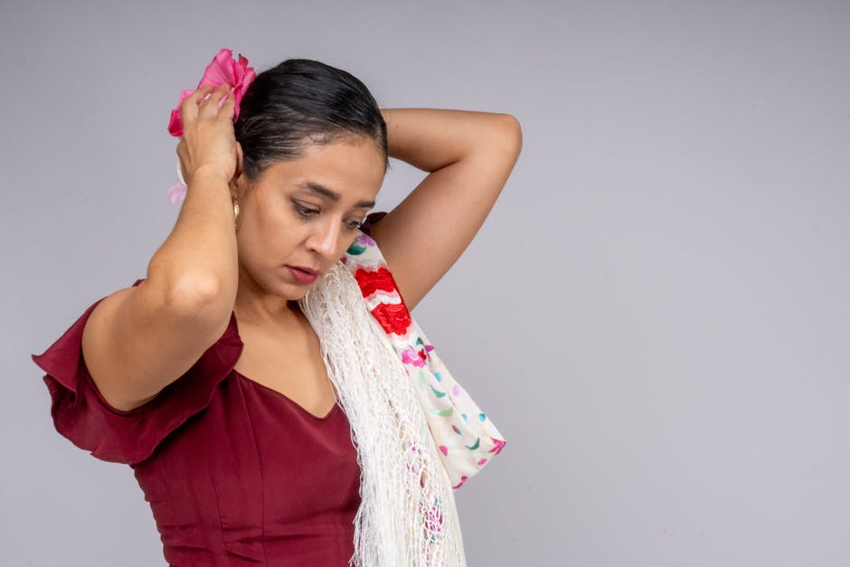 Young woman in traditional red flamenco attire with floral hair accessory