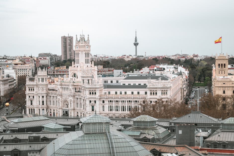 Aerial view of the iconic Palacio de Cibeles and Madrid cityscape under blue sky