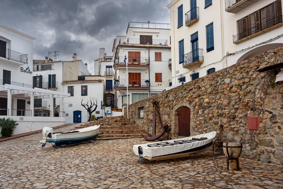 Rustic charm of Costa Brava coast with boats and historic stone buildings