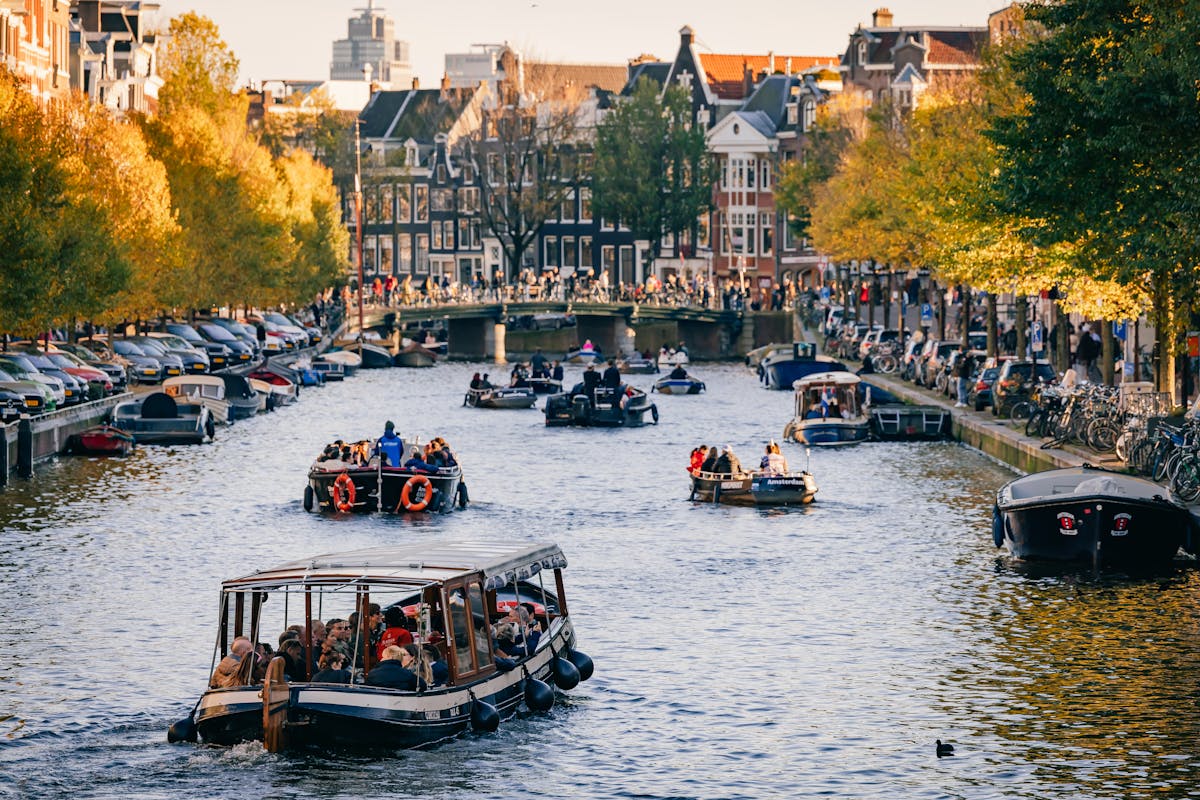 Tourists on a canal cruise boat enjoying the scenic views of Amsterdam canals