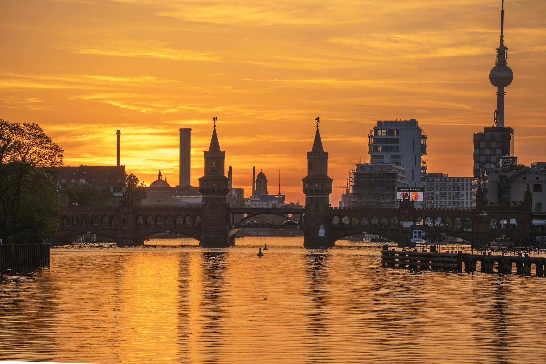 Oberbaum Bridge and TV Tower against sunset over Spree River