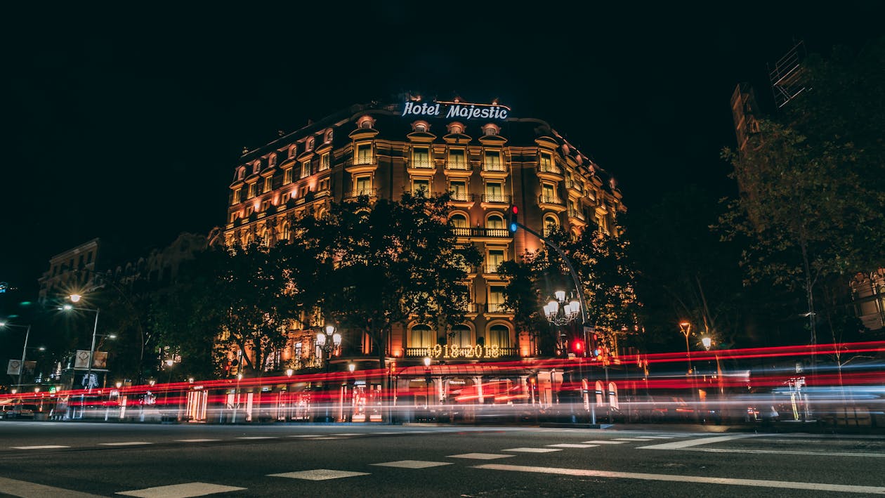 Illuminated historic building in Barcelona captured at night with light trails