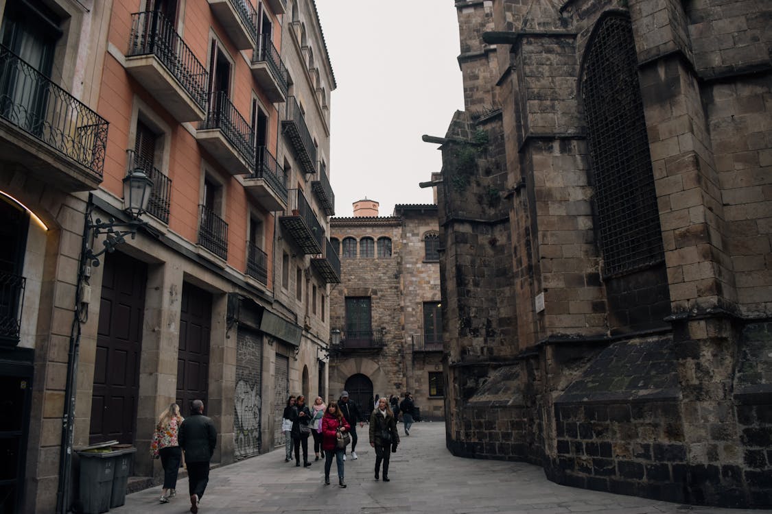A lively alley in Barcelona filled with people against historic building facades