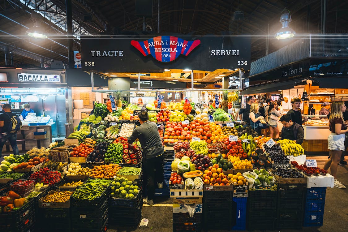 Colorful market stall displaying fresh fruits and vegetables in Barcelona