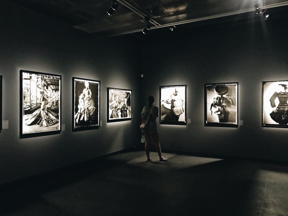 A woman admiring black and white photographs in an art gallery