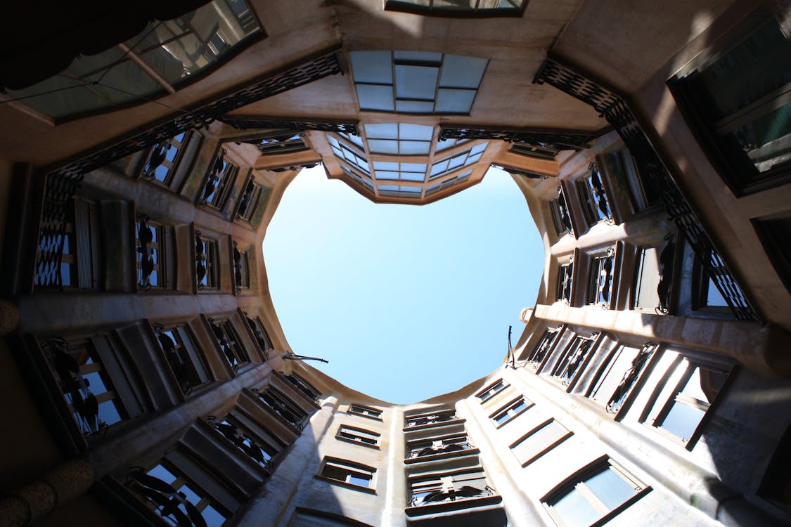 Upward view of the distinctive Casa Mila courtyard in Barcelona showing arched structure