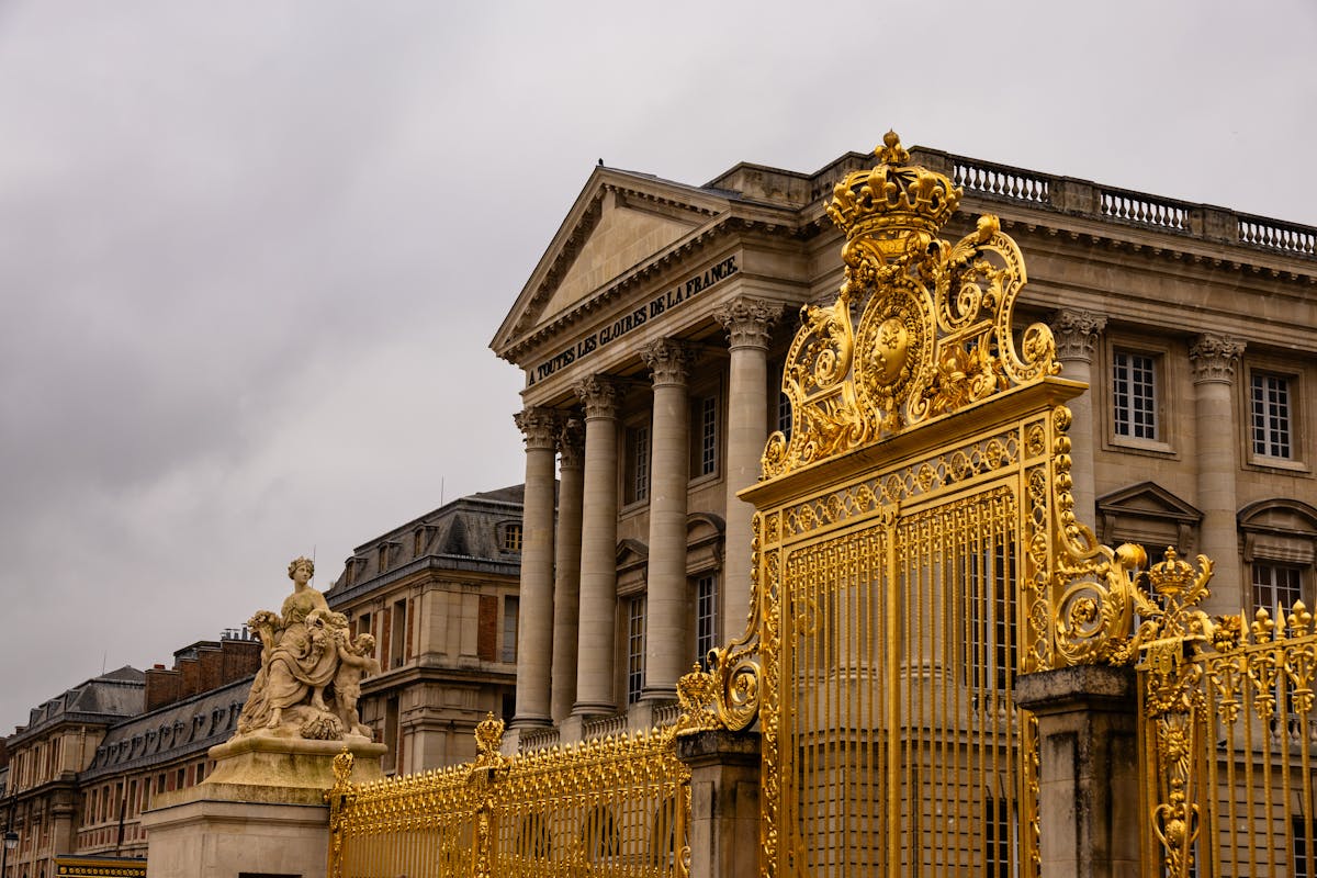 Close-up of the ornate golden entrance gates at the Palace of Versailles