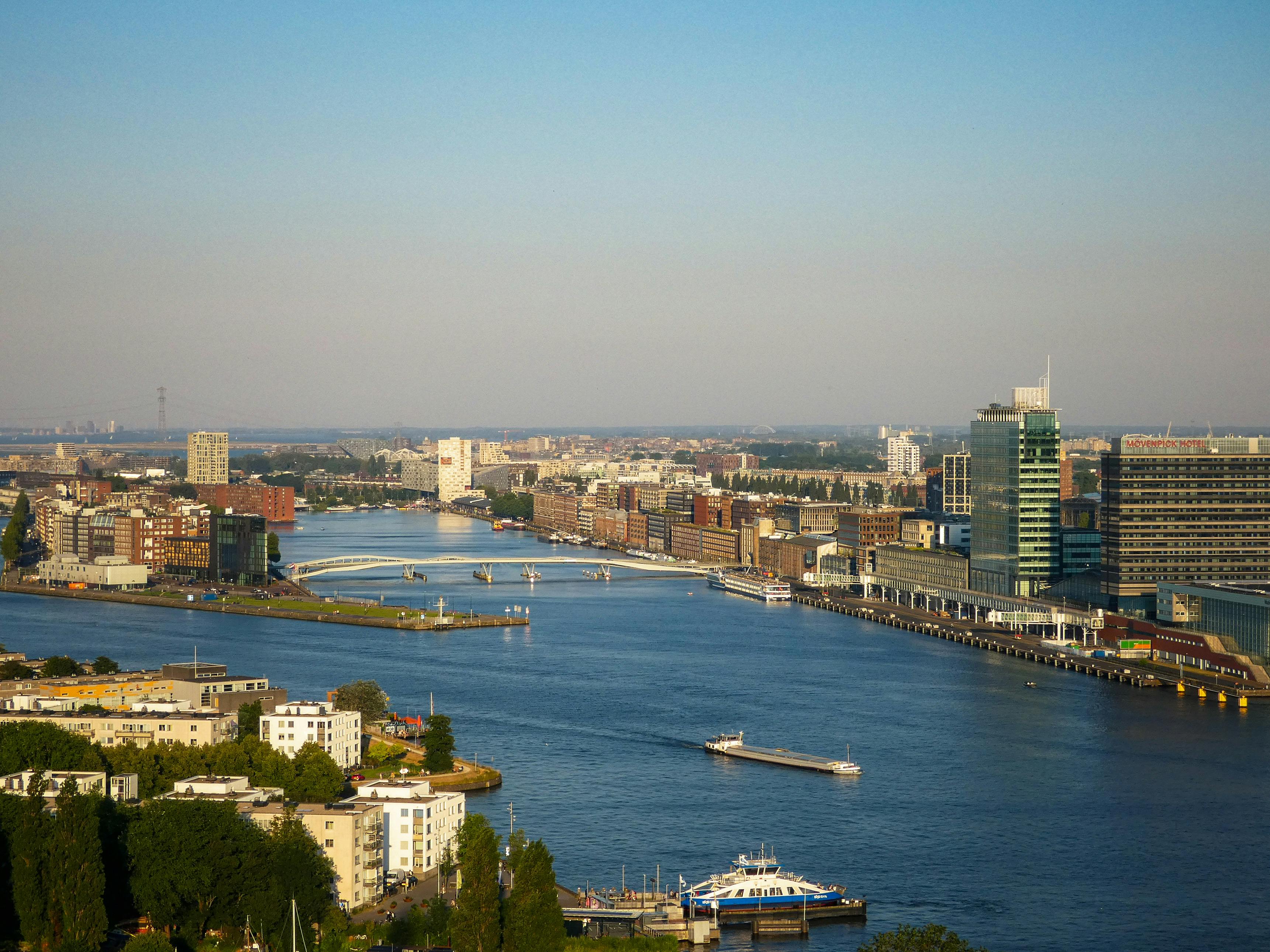 Aerial view of Amsterdam riverfront with modern buildings and the IJ river