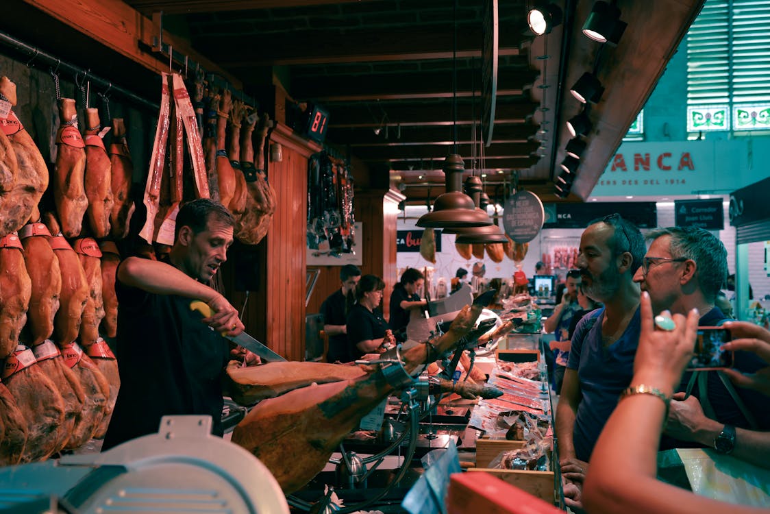 A Barcelona market scene featuring a butcher slicing authentic Spanish ham