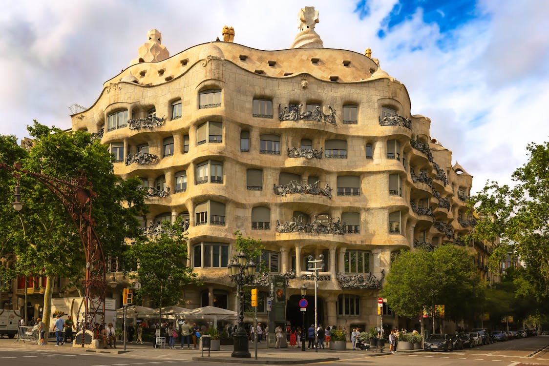 Stunning view of Casa Mila Antoni Gaudi iconic building in Barcelona Spain with tree