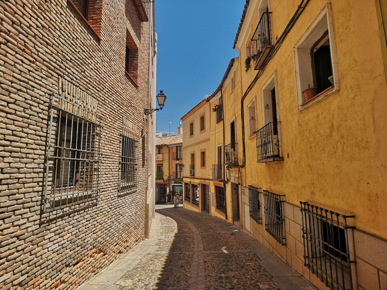 Narrow alley with colorful buildings on a sunny day in Toledo Spain