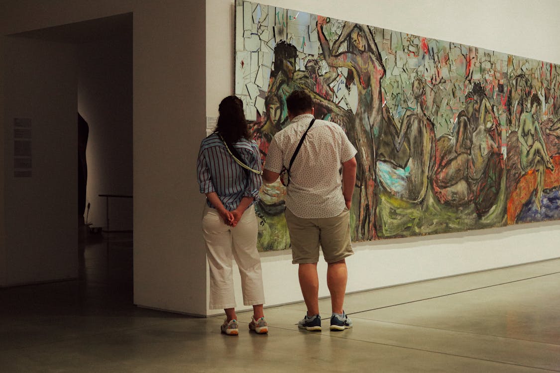 Two adults observe a large abstract painting in a modern art museum gallery