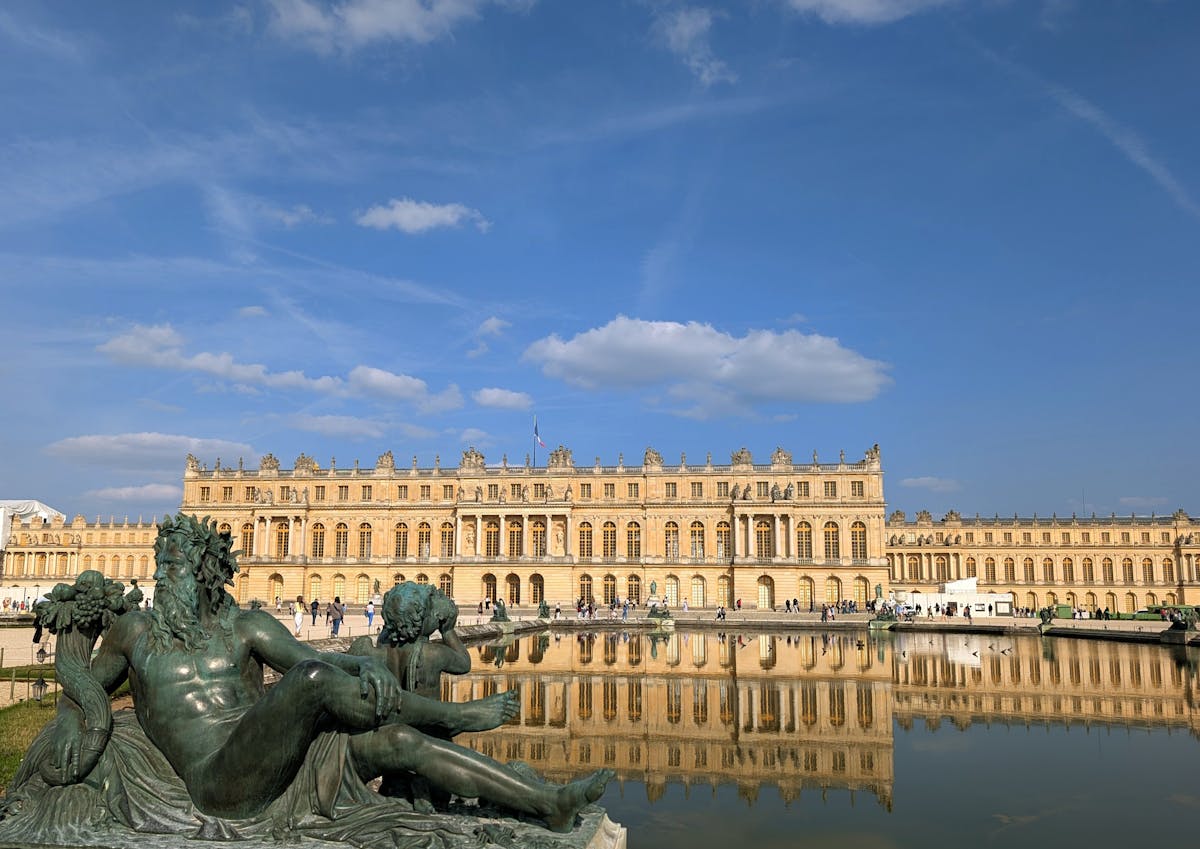 Breathtaking view of the Palace of Versailles with sculptured gardens in foreground